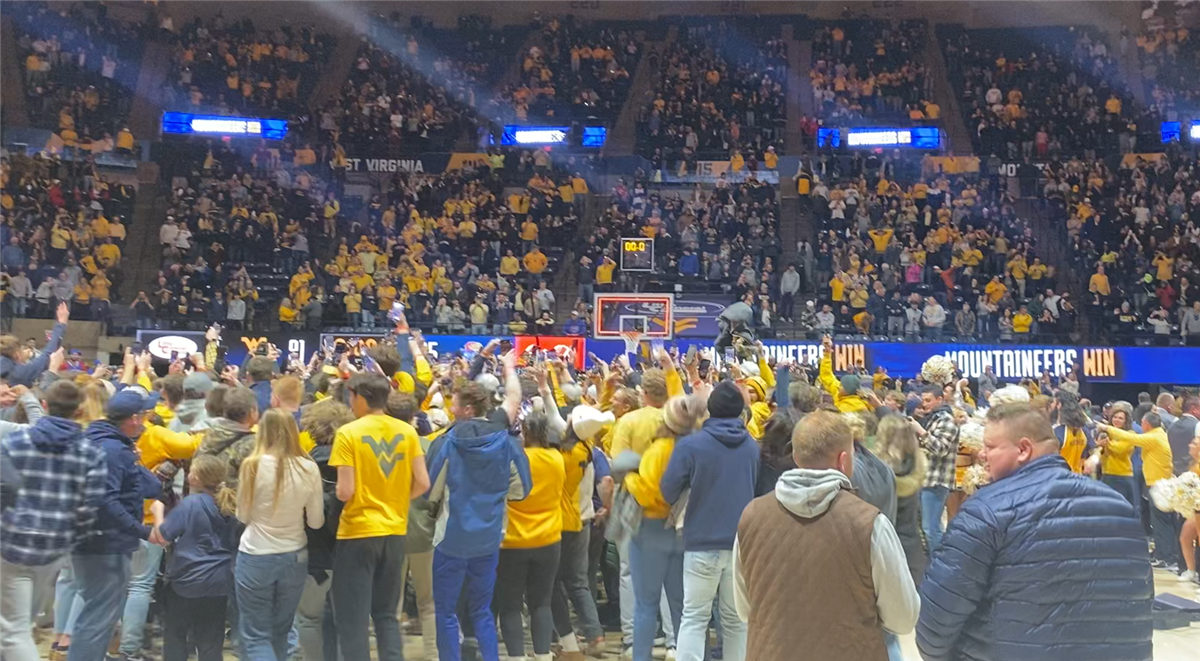 Courtside view of WVU fans storming the court after a win over No. 3 Kansas