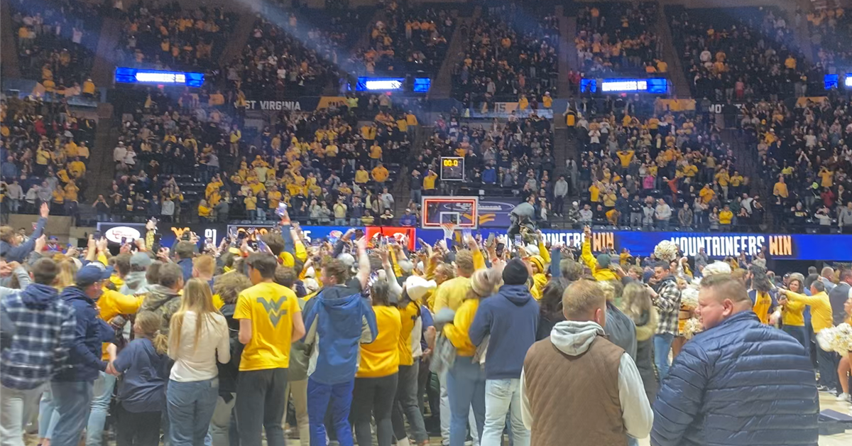 Courtside view of WVU fans storming the court after a win over No. 3 Kansas